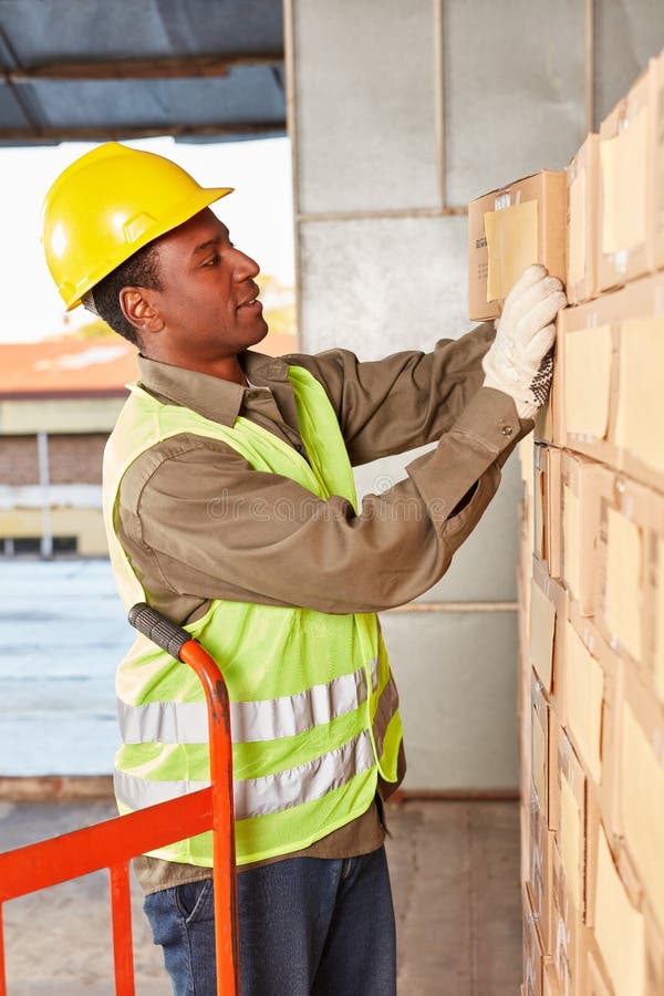 Warehouse Worker Picks Up a Package from the Warehouse Stock Image ...