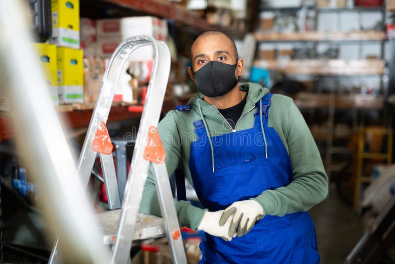 Warehouse Worker in Protective Mask Stands Next To Stepladder and Tool ...
