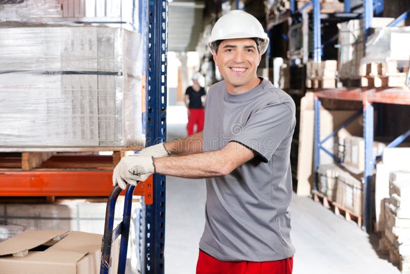 Warehouse Worker Pushing Handtruck with Cardboard Stock Photo - Image ...