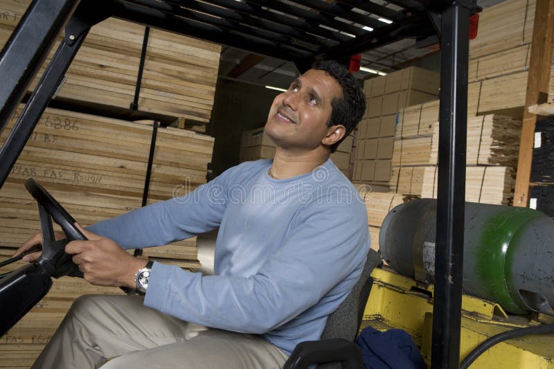 Warehouse Worker Sitting in Forklift and Looking Up Stock Image - Image ...