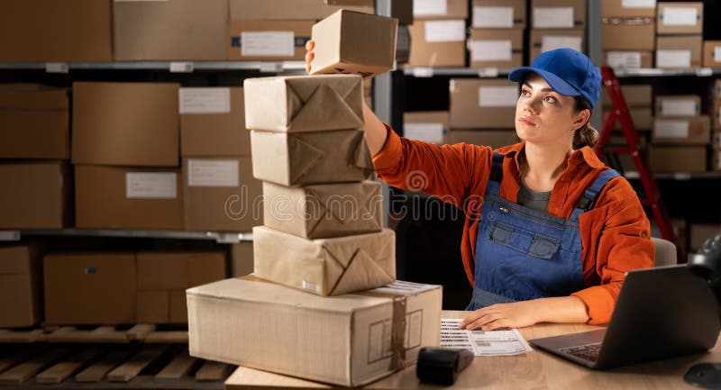 Warehouse Worker Sorts Parcels while Working Using Laptop Computer in ...