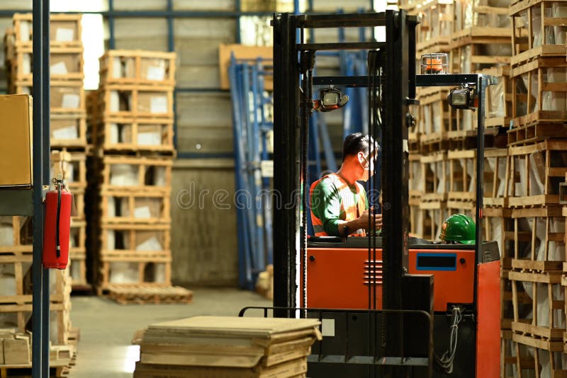 Warehouse Worker in Uniform Loading Cardboard Boxes with Forklift in ...