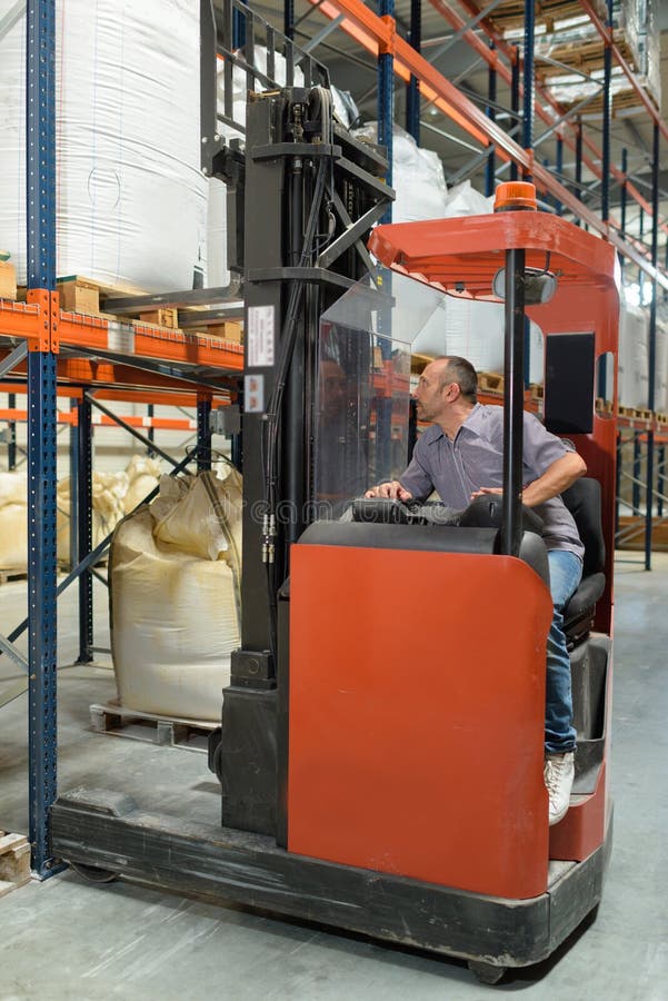 Warehouse Worker Using Fork Truck To Load Pallet on Racking Stock Photo ...
