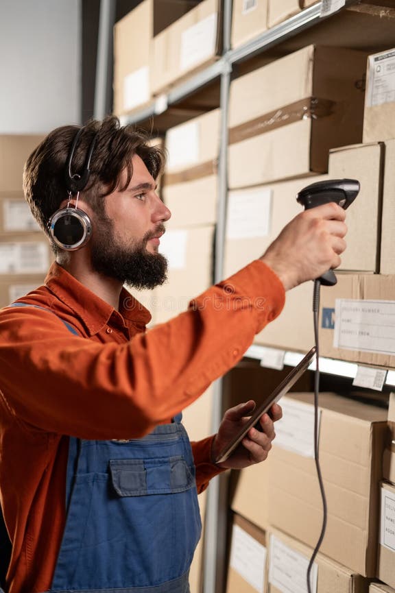 Warehouse Worker in Wireless Headset Scanning Barcodes on Boxes in a ...