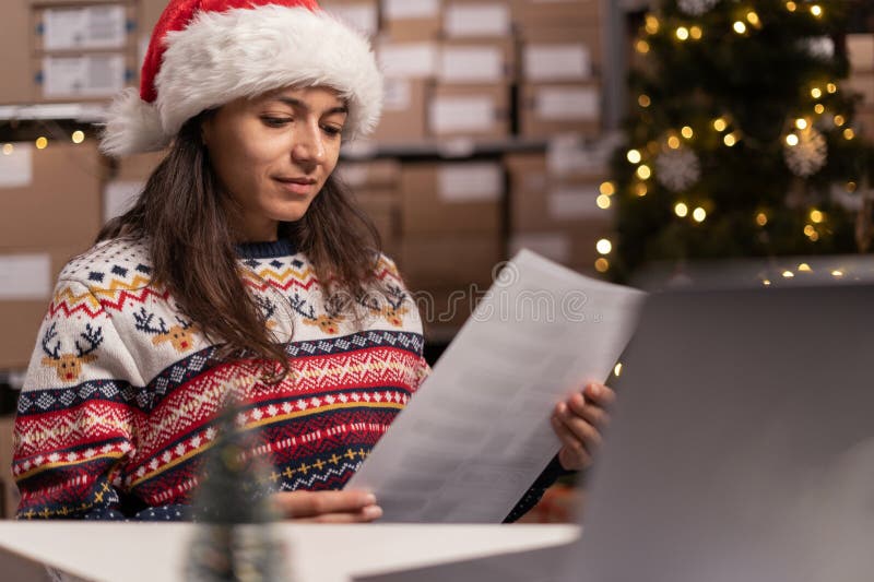 Warehouse Worker Working on Christmas Day Sitting at Table Looking at ...