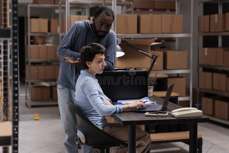 Warehouse Workers Analyzing Checklist on Laptop Computer Searching for ...