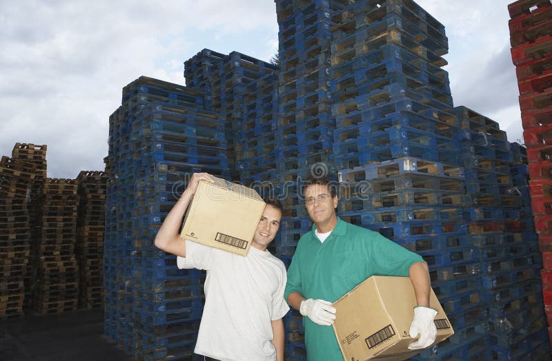 Warehouse Workers Carrying Boxes Against Pallets Stock Image - Image of ...