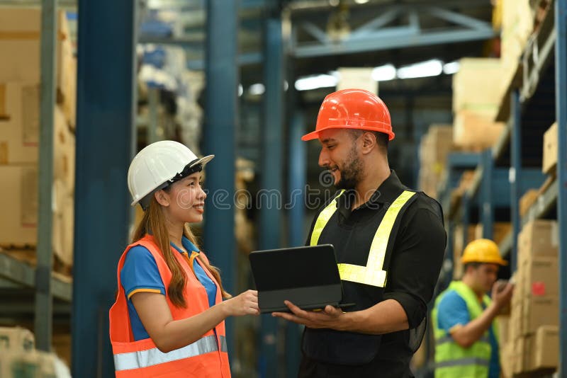 Warehouse Workers in Safety Uniform Working in Warehouse Full of Tall ...