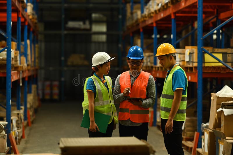 Warehouse Workers in Safety Uniform Working in Warehouse Full of Tall ...