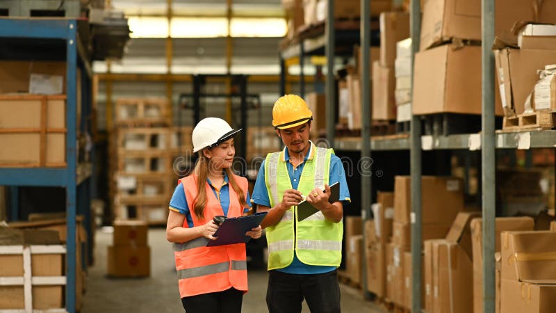 Warehouse Workers Wearing Safety Hardhat Discussing Work while Walking ...