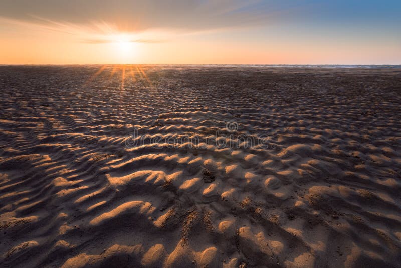 Warm Afternoon Sun Rays on a Beach at Low Tide with Sand Patterns in ...