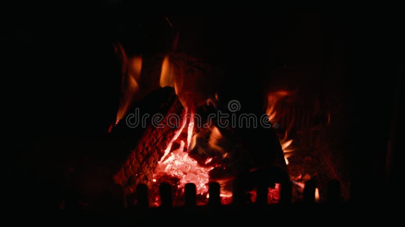 Warm Fire Slowly Burning Inside Dark Fireplace, Casting Soft Flickering Light and Generating ...