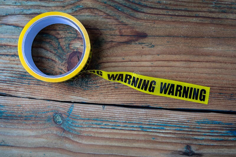 Warning Tape on a Wooden Texture Table. Information, Containment and ...