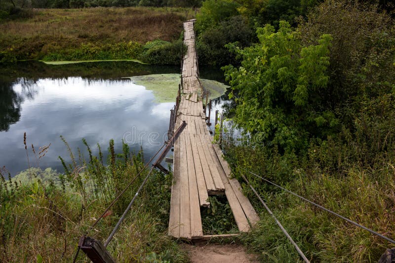 Warped and Lying on the Water Footbridge Across the River Stock Image ...