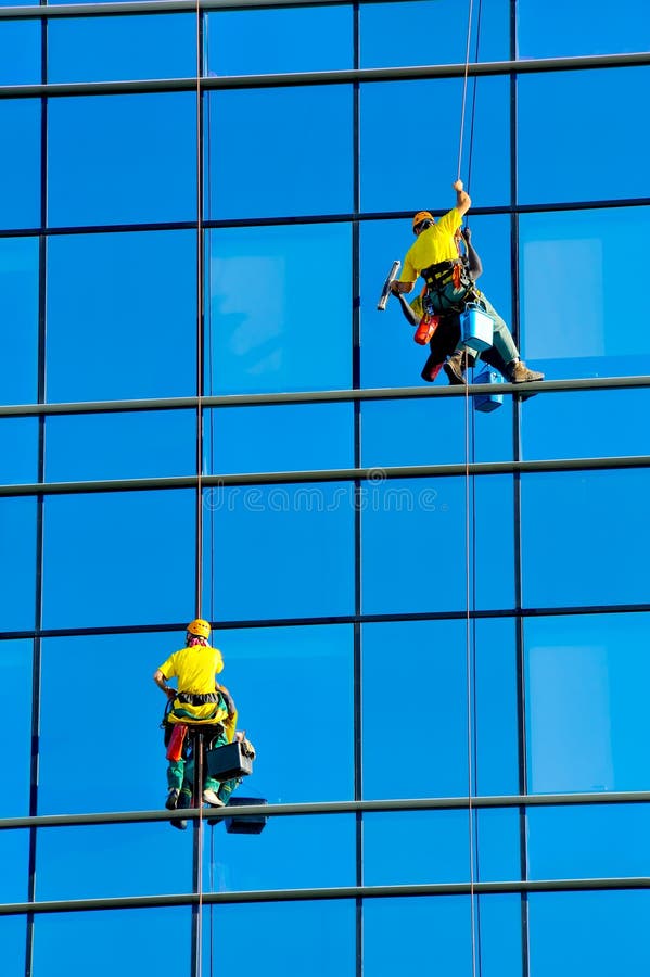 Washers Wash the Windows of Modern Skyscraper. Window Cleaner Working ...