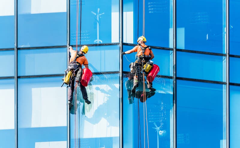 Washers Wash the Windows of Modern Skyscraper. Window Cleaner Working ...