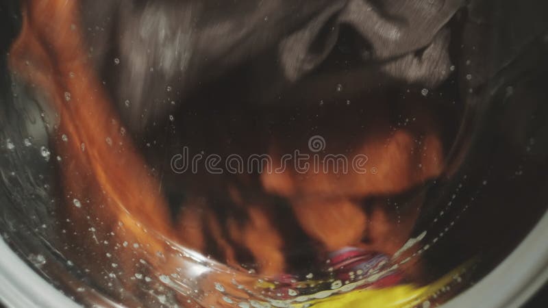Close-up of Dirty Laundry Spinning Inside Washing Machine Drum. Laundry ...