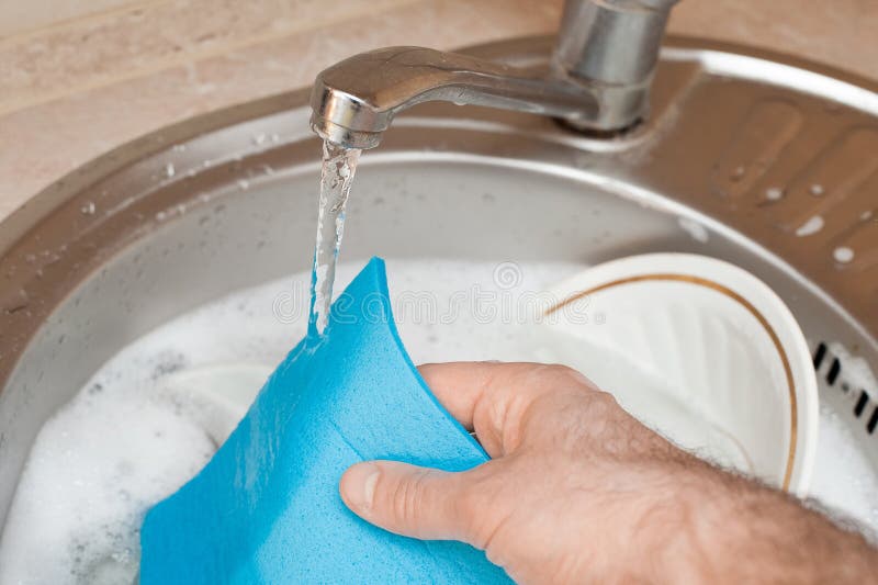Man S Hand with a Blue Rag for Washing Dishes in the Kitchen. an Image ...
