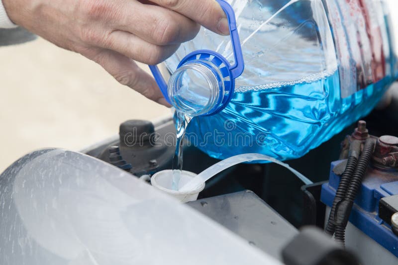 Washing Liquid for the Windshield of the Car. a Man Pours Washing ...