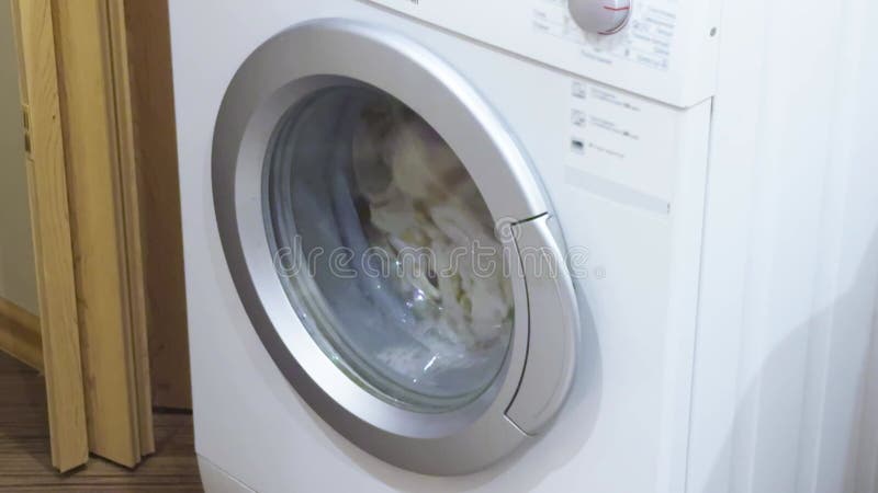 A Washing Machine in Action with Visible Rotating Laundry Behind the ...