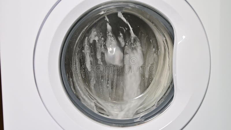 Washing Machine Door with Rotating Garments Inside. Focus in the Center ...