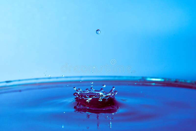 Wassertropfen Fallend Im Blauen Wasser Und Im Blauen Hintergrund ...