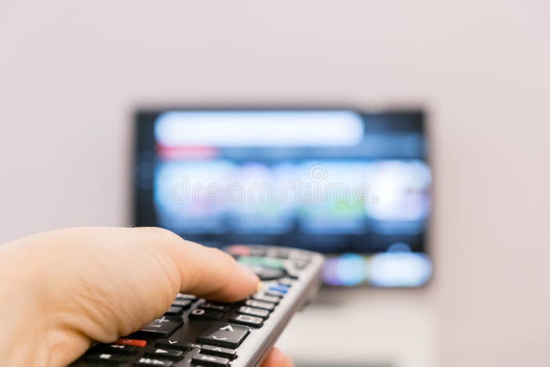 Watching TV and Using Remote Controller. Hand Holding TV Remote Control ...