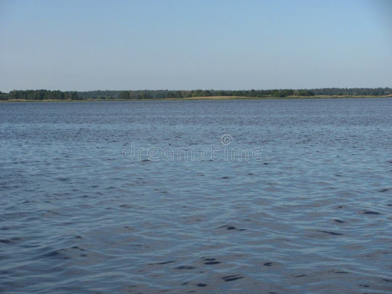 Water Area with Ripples and Forest on the Horizon Stock Image - Image ...