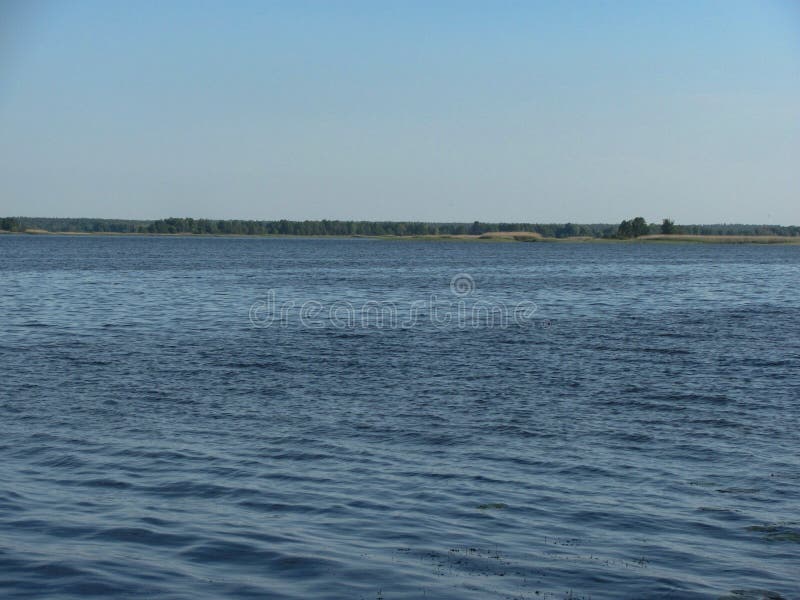 Water Area with Ripples and Forest on the Horizon Stock Photo - Image ...