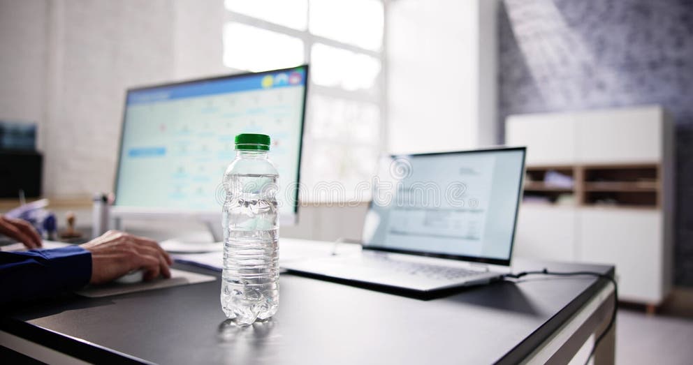 Water Bottle on Desk and Man in Background Stock Image - Image of ...