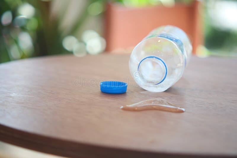 A Water Bottle and Its Cap Have Been Accidentally Spilled All Over the ...