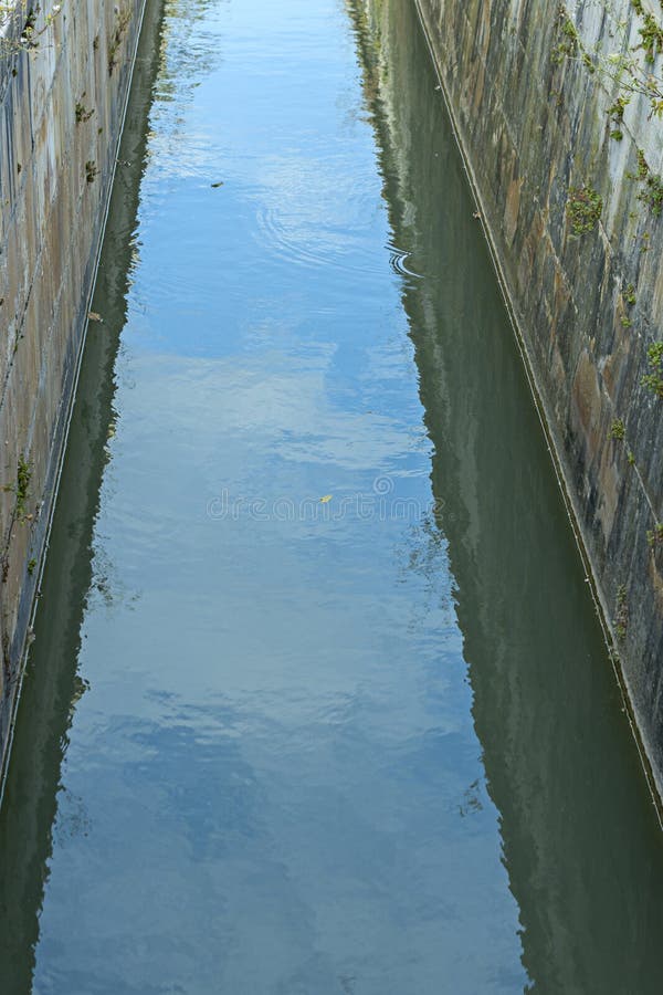 A Water Channel through Stone Walls Reflecting the Sky on the Surface ...