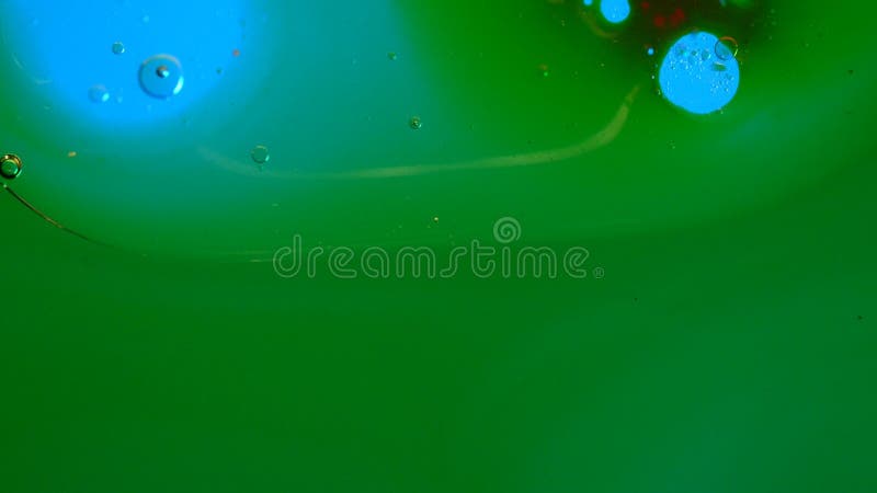 Green Colored Water Surface with Blurred Oil Droplets and Ink Flows ...
