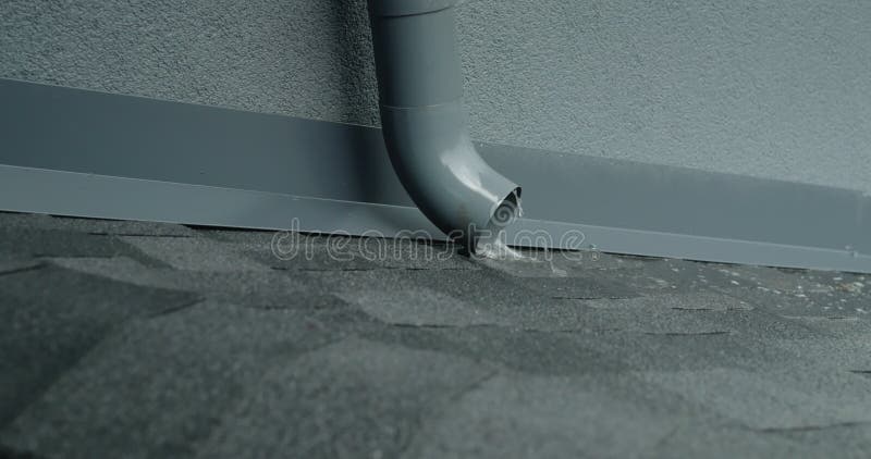 Water from the Drain Pipe Flows Onto the Roof of Shingles Stock Footage ...