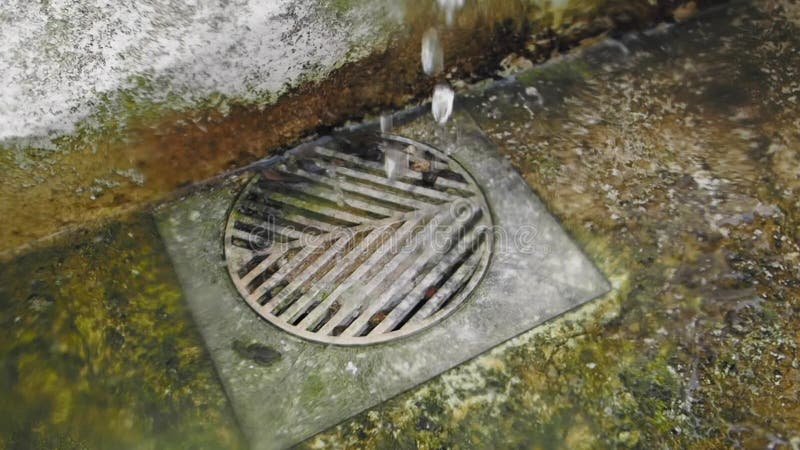 Water Flowing into Rusty Drainage Grate in Urban Setting Stock Footage ...