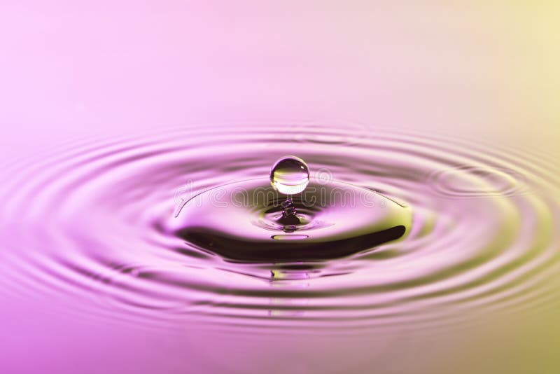 Water Drop Close Up with Concentric Ripples Colourful Pink and Y Stock ...