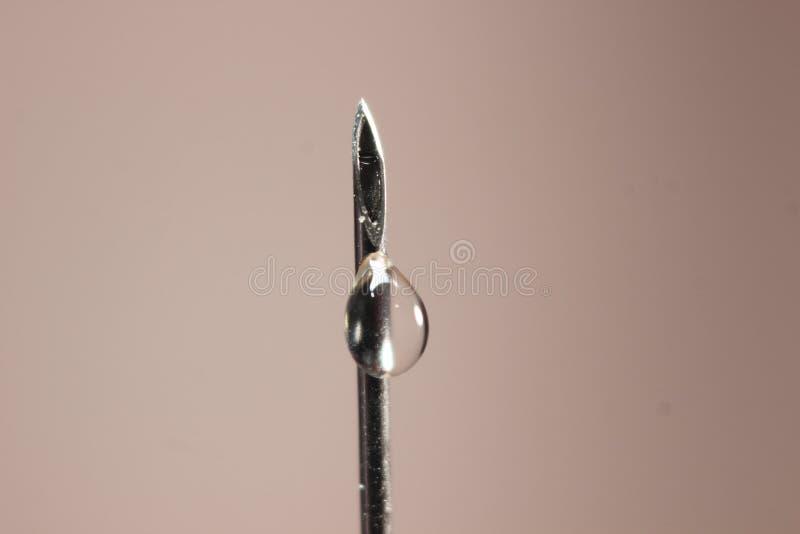 Water Drop Falling from the Syringe Needle Against Grey Background ...