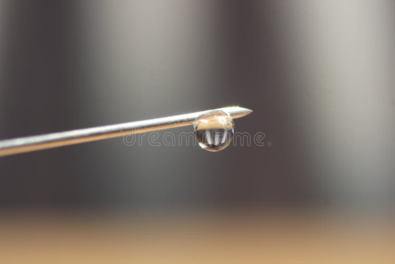 Water Drop Falling from the Syringe Needle Against Grey Background ...
