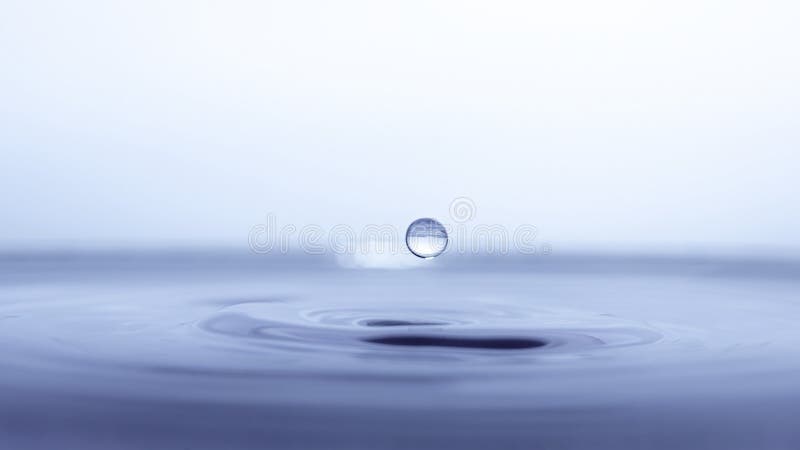 Water Drop Splash in a Glass Blue Colored Stock Photo - Image of ...