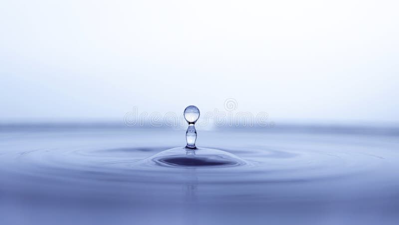 Water Drop Splash in a Glass Blue Colored Stock Photo - Image of ...