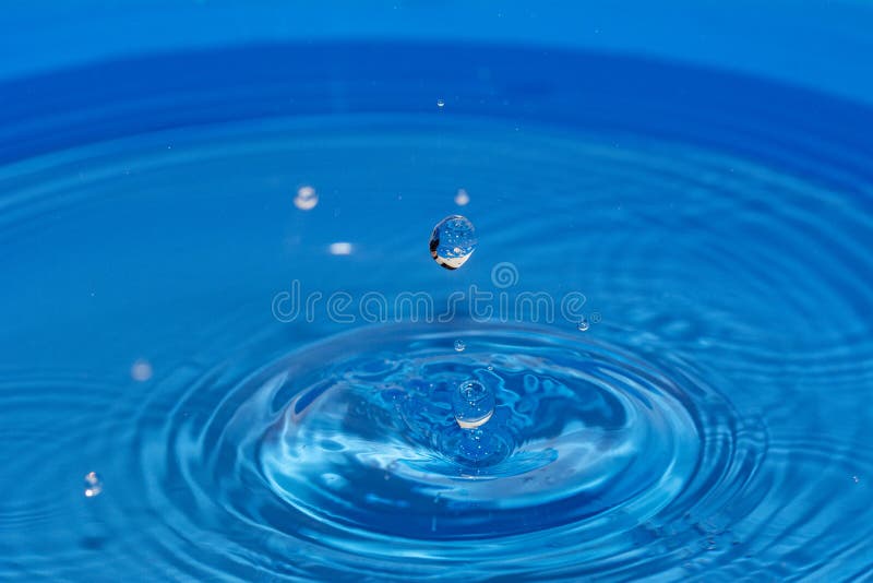 Water Drop Splash in a Glass Blue Colored Stock Image - Image of light ...