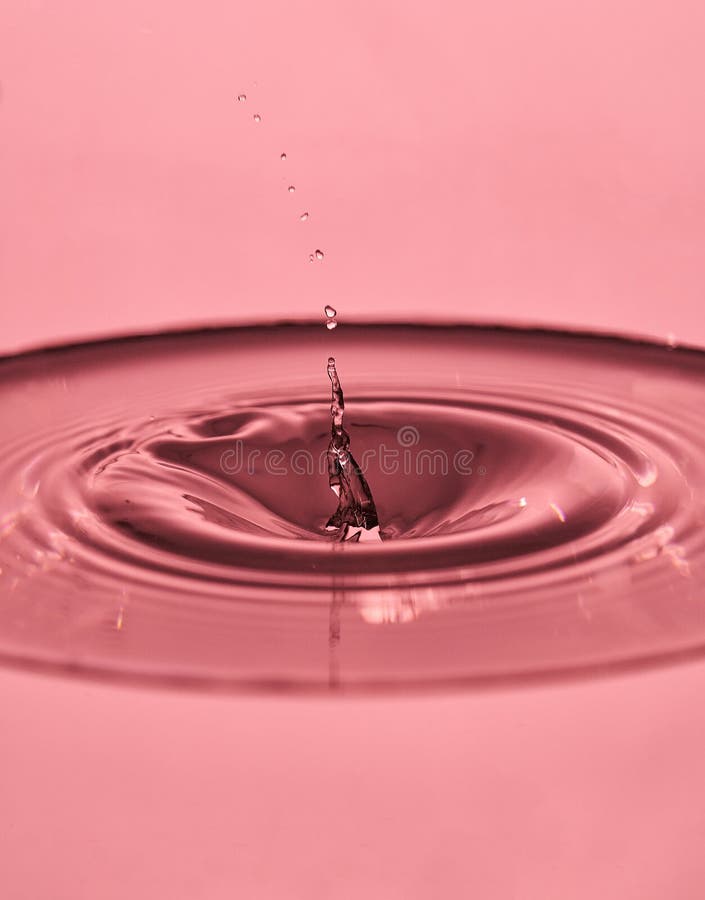Water Drop Splash in a Glass Rose Colored Stock Image - Image of glass ...