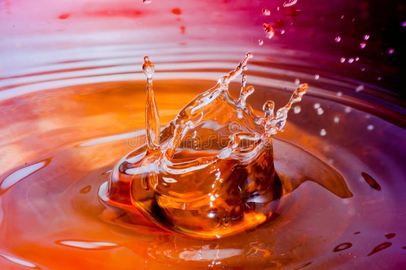 Water Droplet Causes a Splash in Multi-coloured Water Stock ...