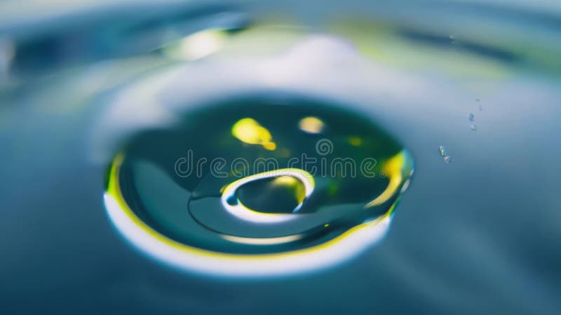Water Droplet Creating Concentric Circles on Blue Liquid Surface Stock ...
