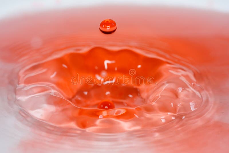Water Droplet Falling on the Red-colored Water Surface Stock Image ...