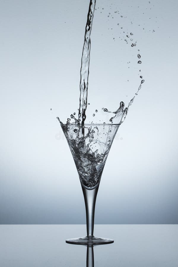 Water Fall into a Glass and Splash on a Blue Background Stock Image ...