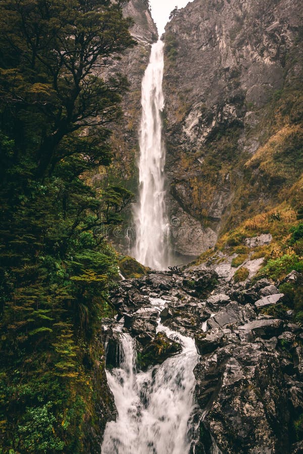 Water Fall from Mountains Running into Stream with Dark Rocks Stock ...