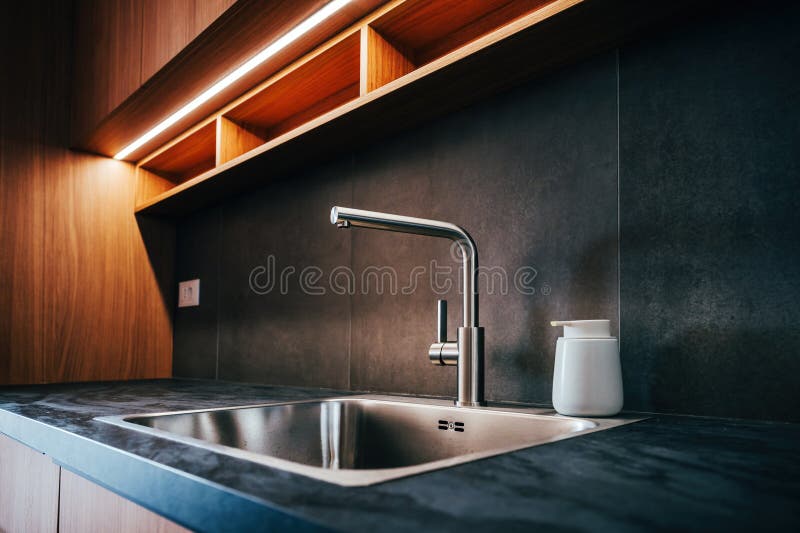 Water Faucet and Metallic Sink in Modern Sleek Kitchen with Led Strip ...