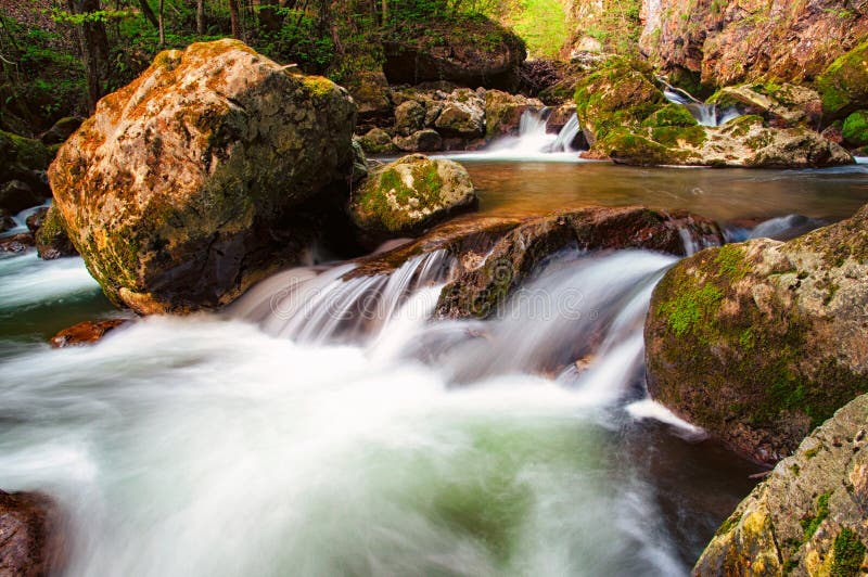 Water flowing around rocks stock image. Image of green - 140755281