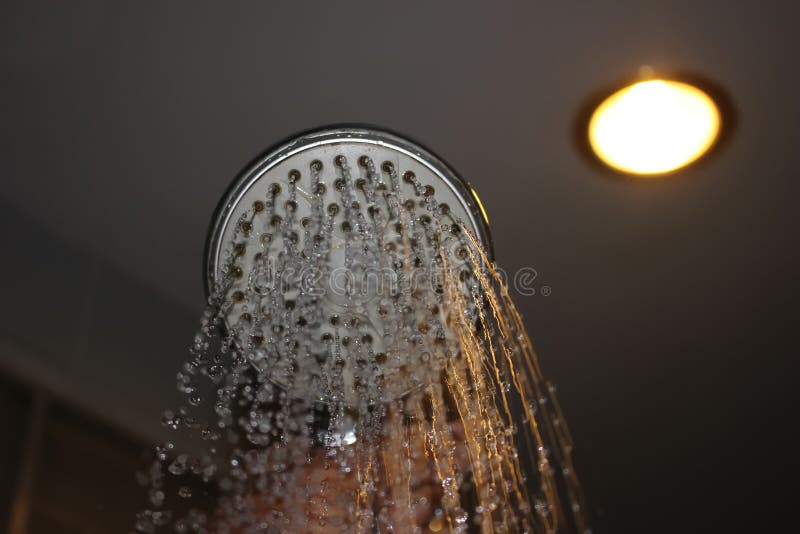 Water Flowing from the Shower with the Reflected Light from the Lamp ...